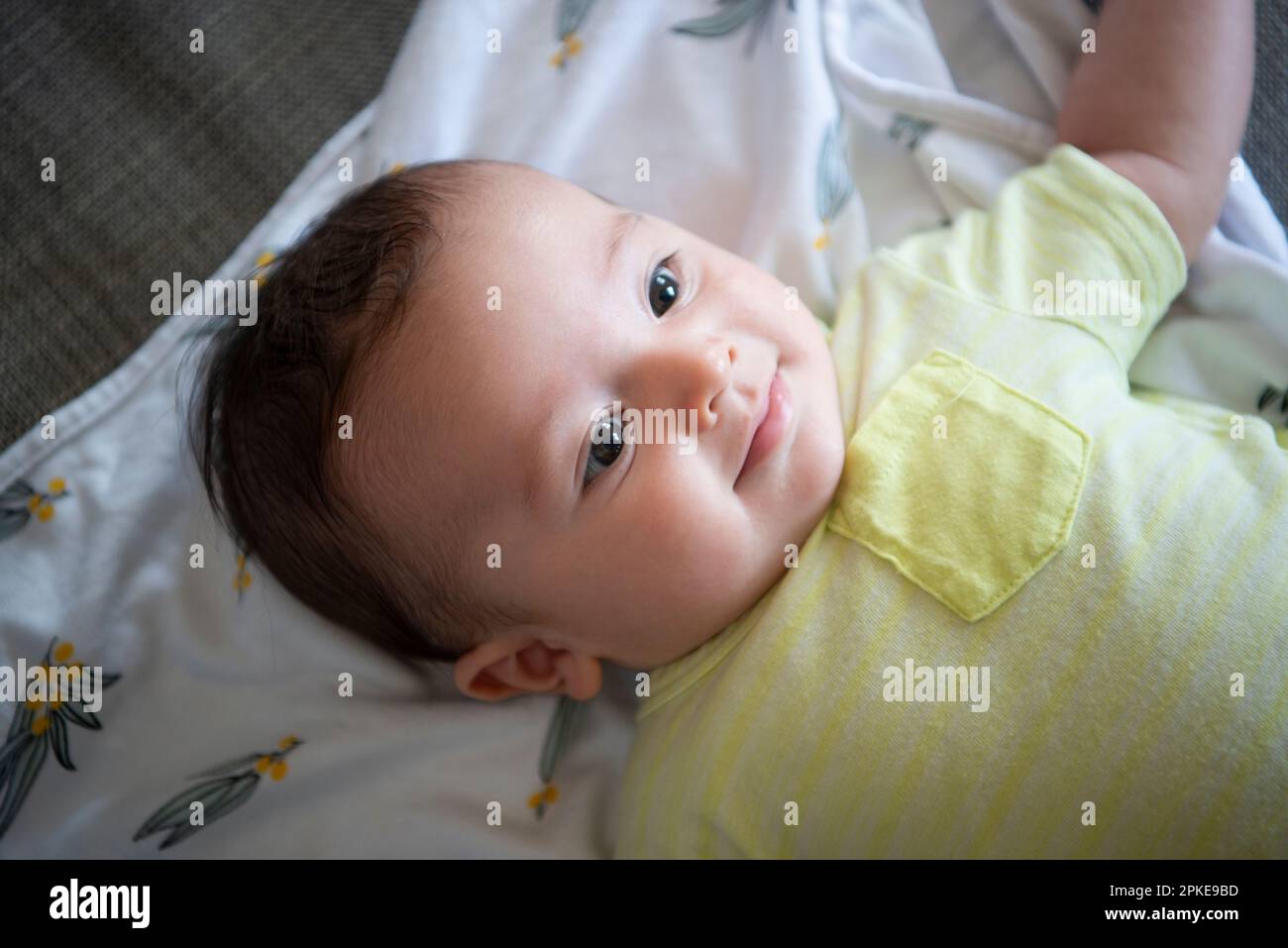 Baby lying down and smiling Stock Photo - Alamy