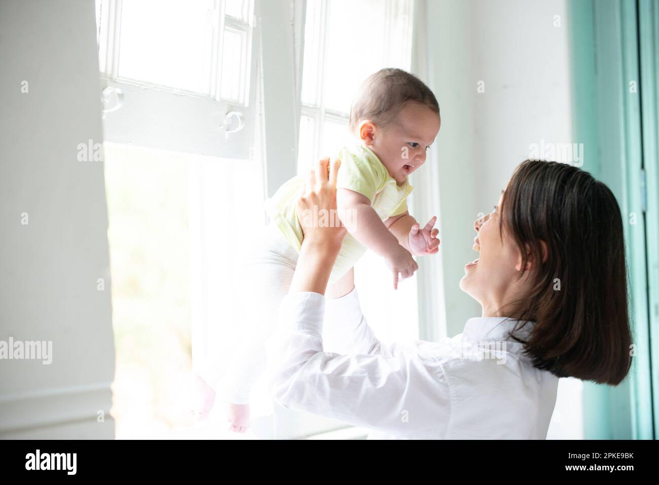 Mother nursing her baby by the window Stock Photo - Alamy