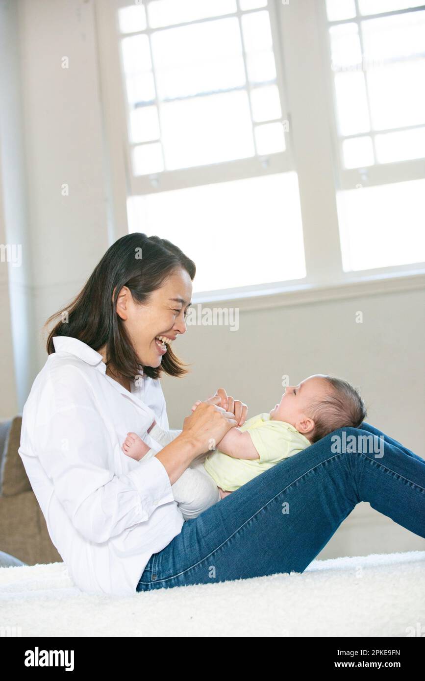 Mother nursing her baby in the house Stock Photo - Alamy