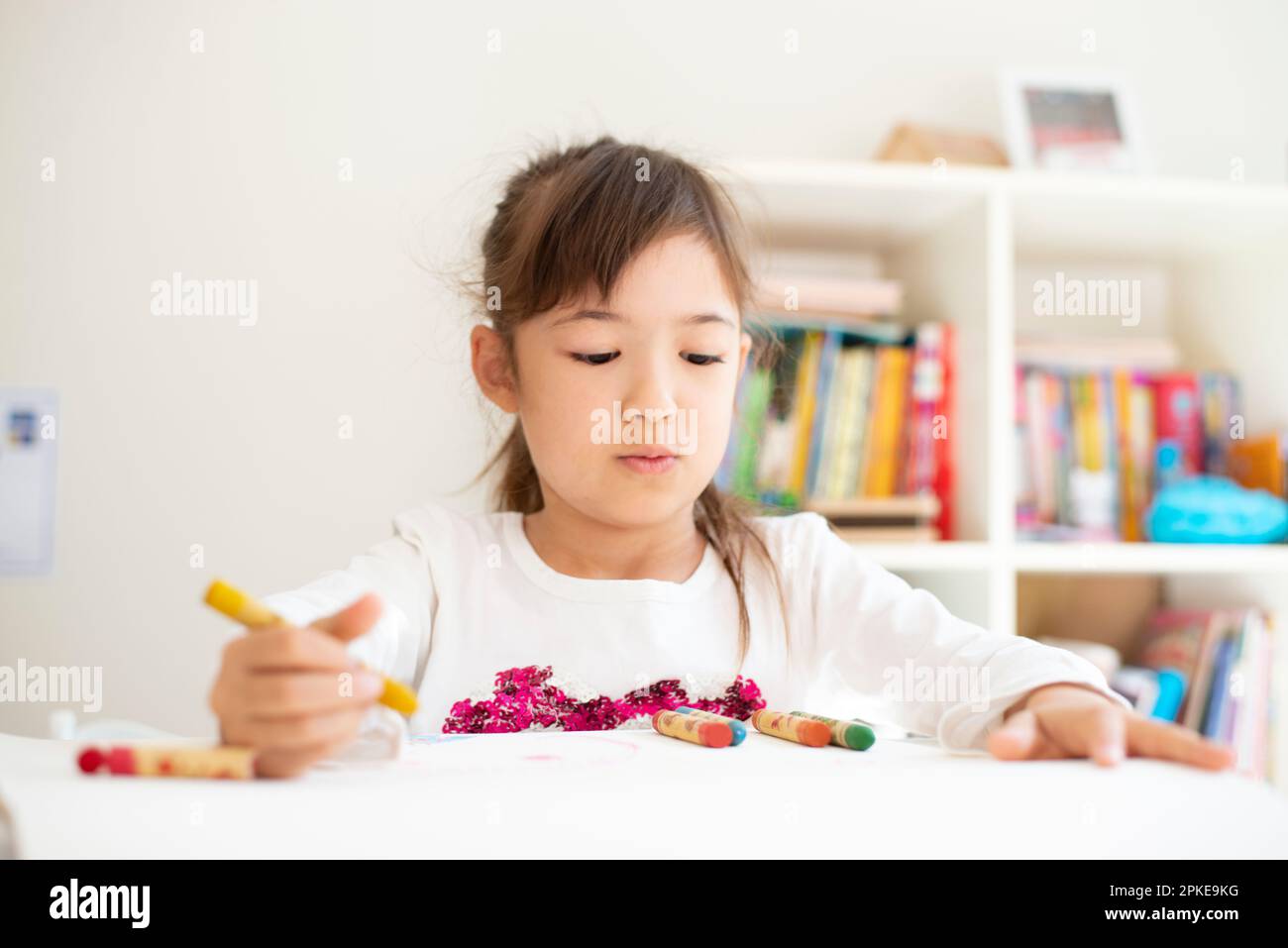 Girl drawing with crayons Stock Photo - Alamy