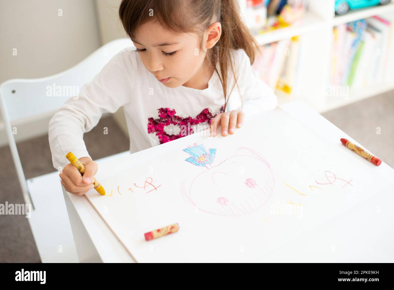 Girl drawing with crayons Stock Photo - Alamy