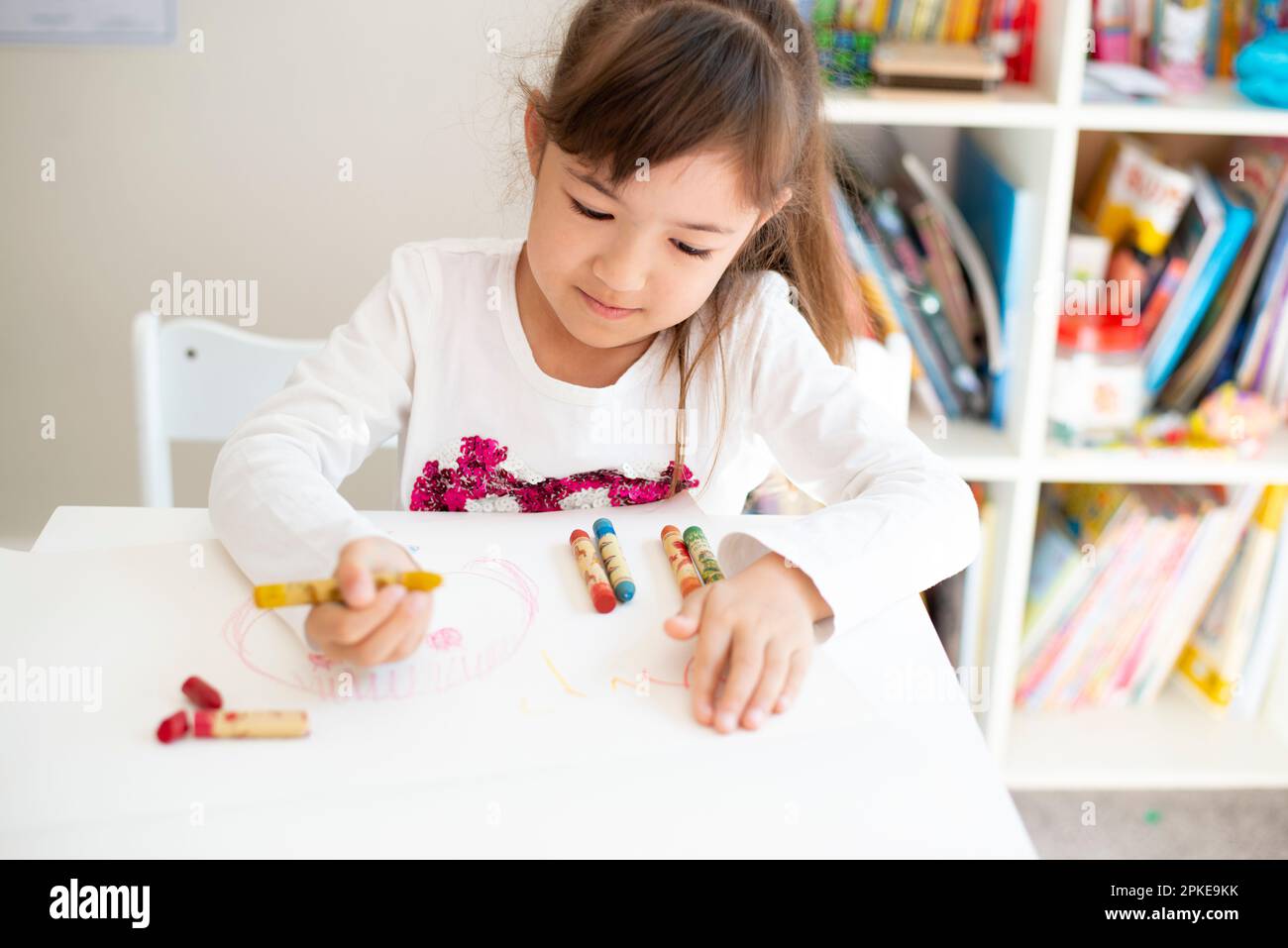 Girl drawing with crayons Stock Photo - Alamy