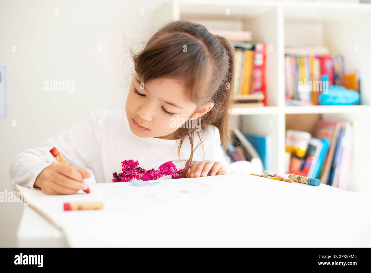 Girl drawing with crayons Stock Photo - Alamy