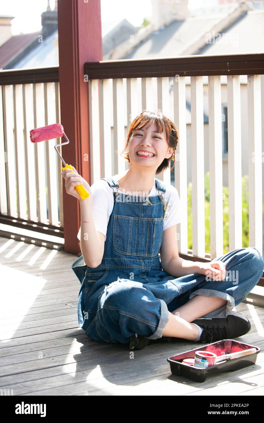 Woman laughing with paint roller Stock Photo - Alamy