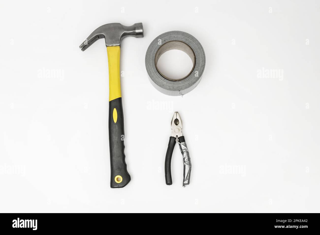 A pair of pliers, a roll of gray adhesive tape and a carpenter's hammer ...