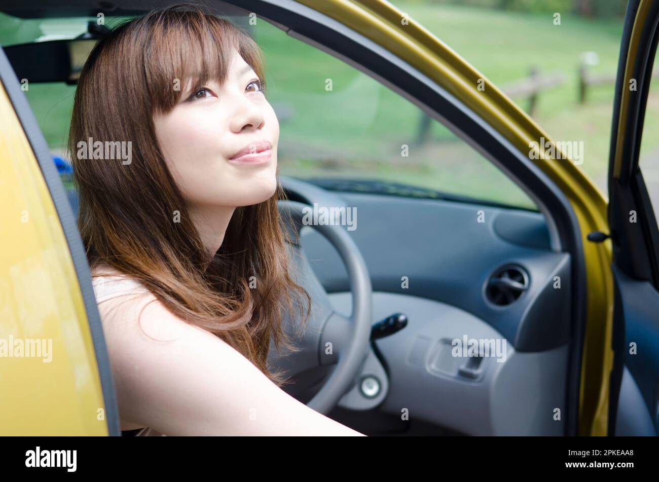 Woman opening car door Stock Photo - Alamy