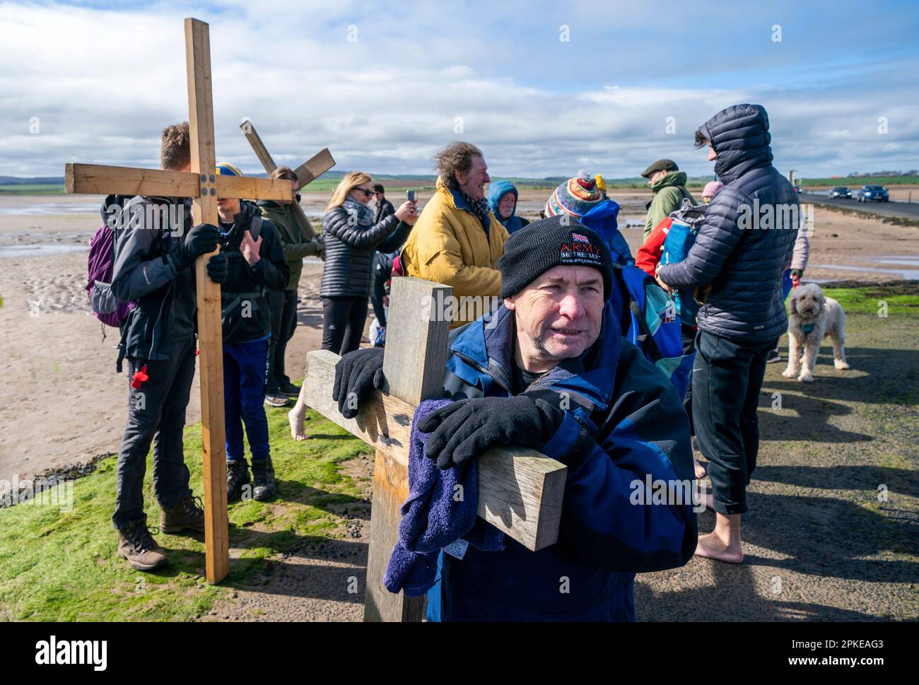 Pilgrims gather at the start of the causeway before carrying crosses ...