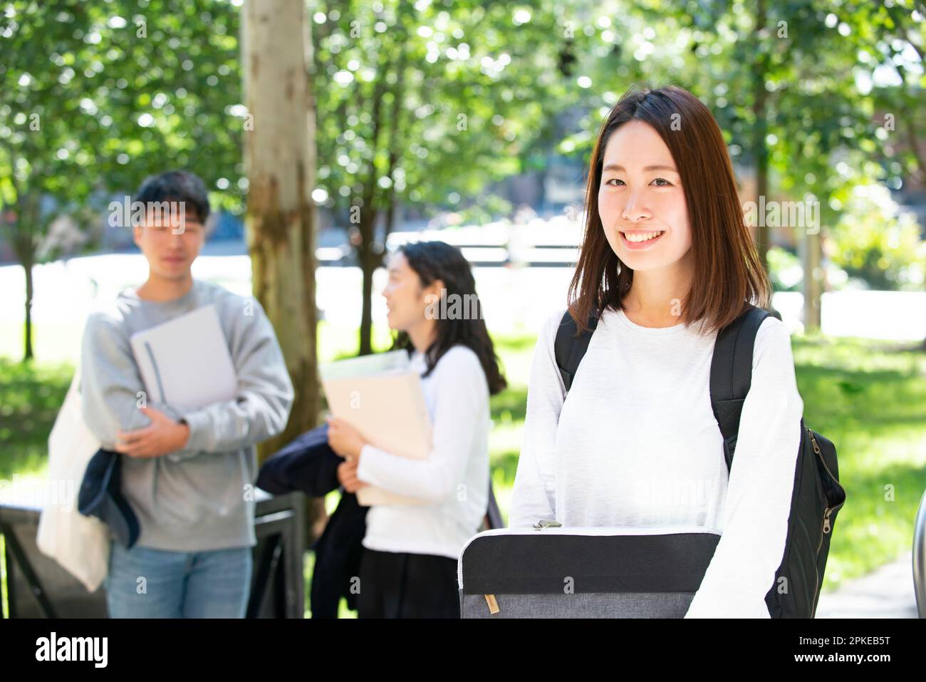 Female student laughing with computer pouch Stock Photo - Alamy