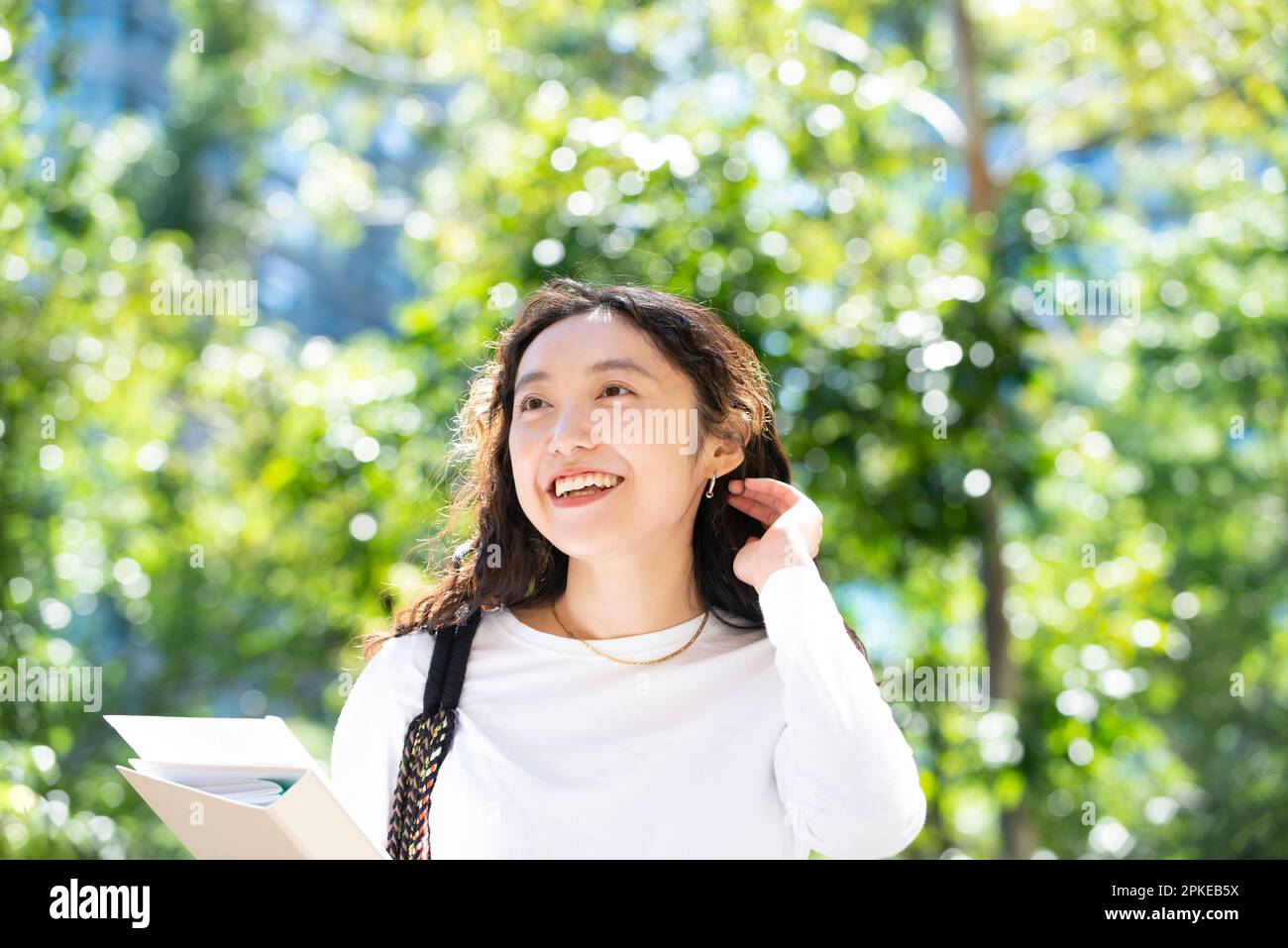 Female student holding notebook and laughing Stock Photo - Alamy