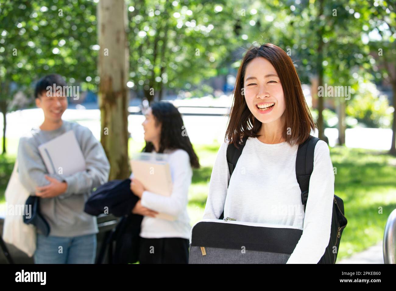 Female student laughing with computer pouch Stock Photo - Alamy