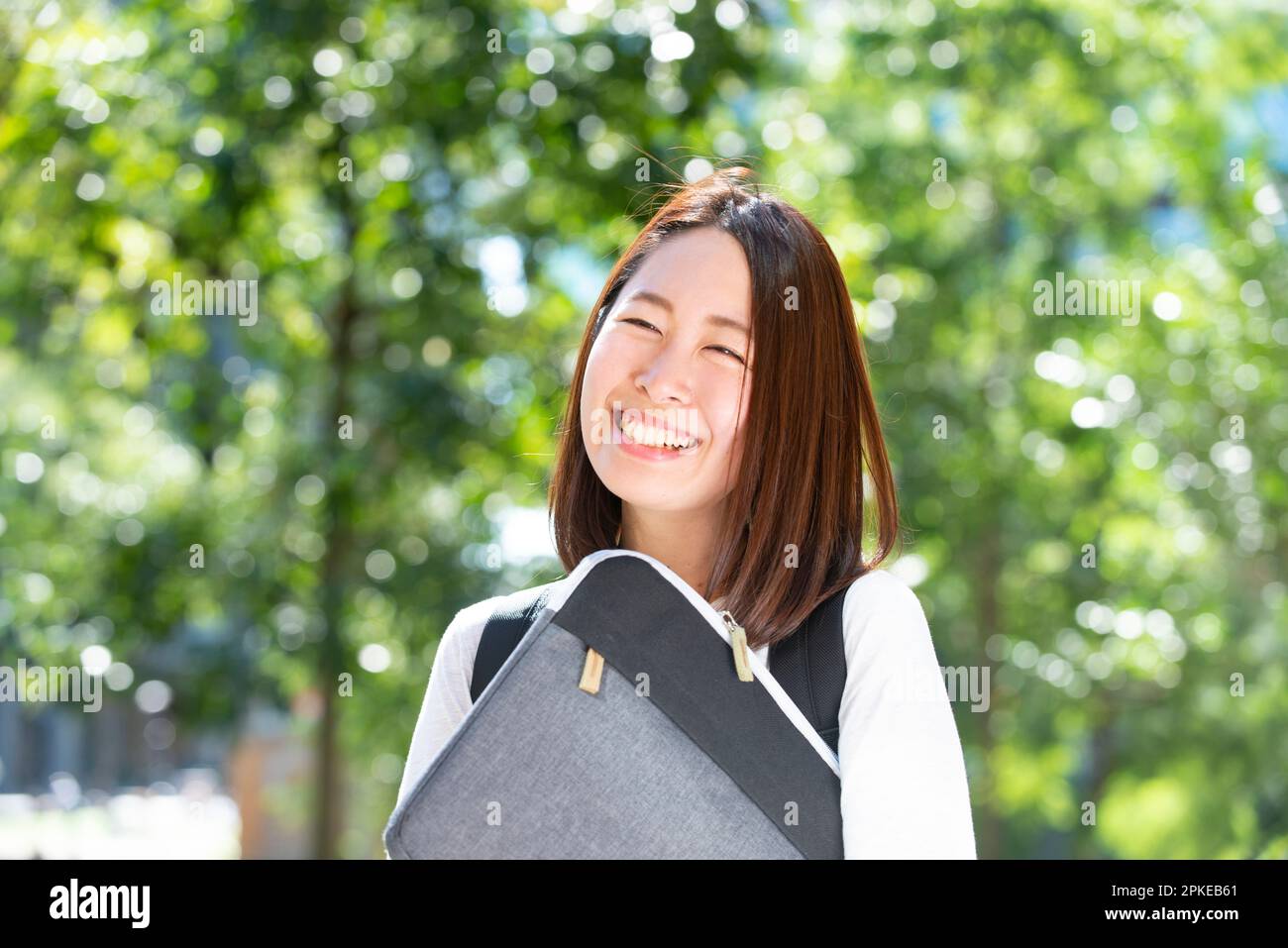 Female student smiling holding computer pouch Stock Photo - Alamy