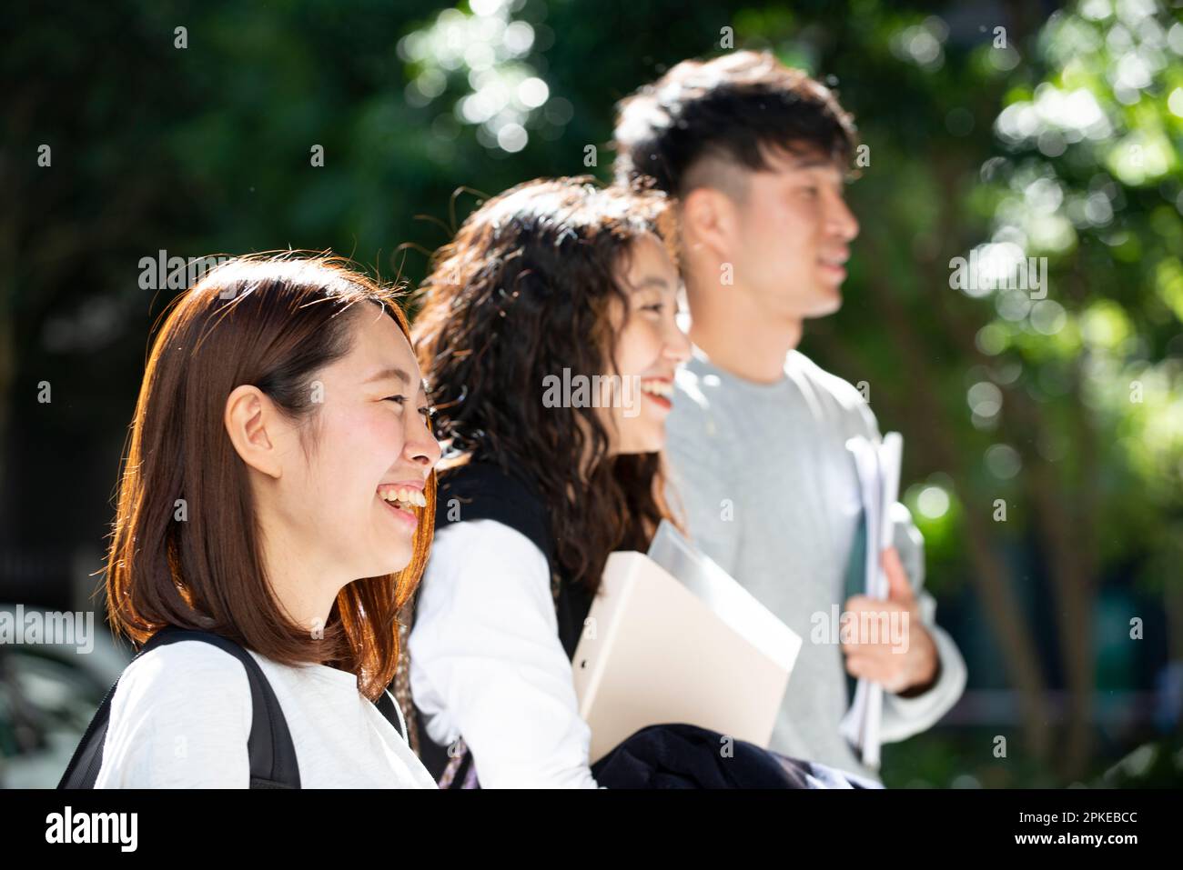 Side profile of three young people laughing side by side Stock Photo ...
