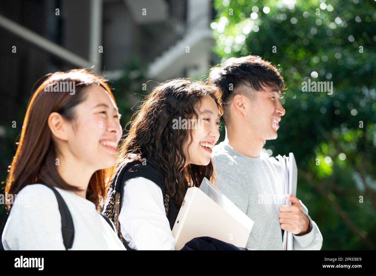 Profile of three young people laughing side by side Stock Photo - Alamy
