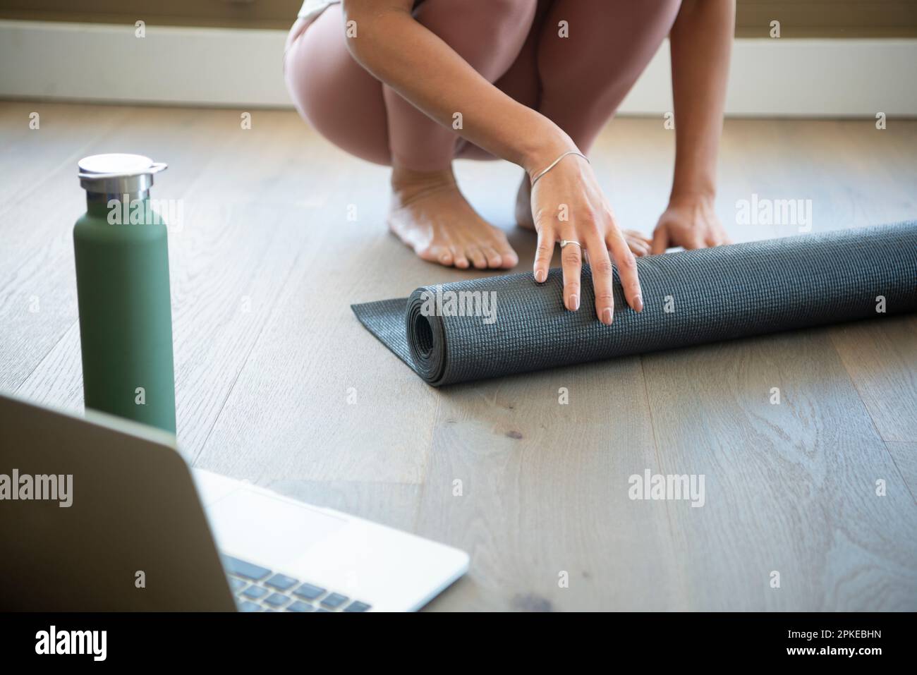 Woman laying out a yoga mat Stock Photo - Alamy