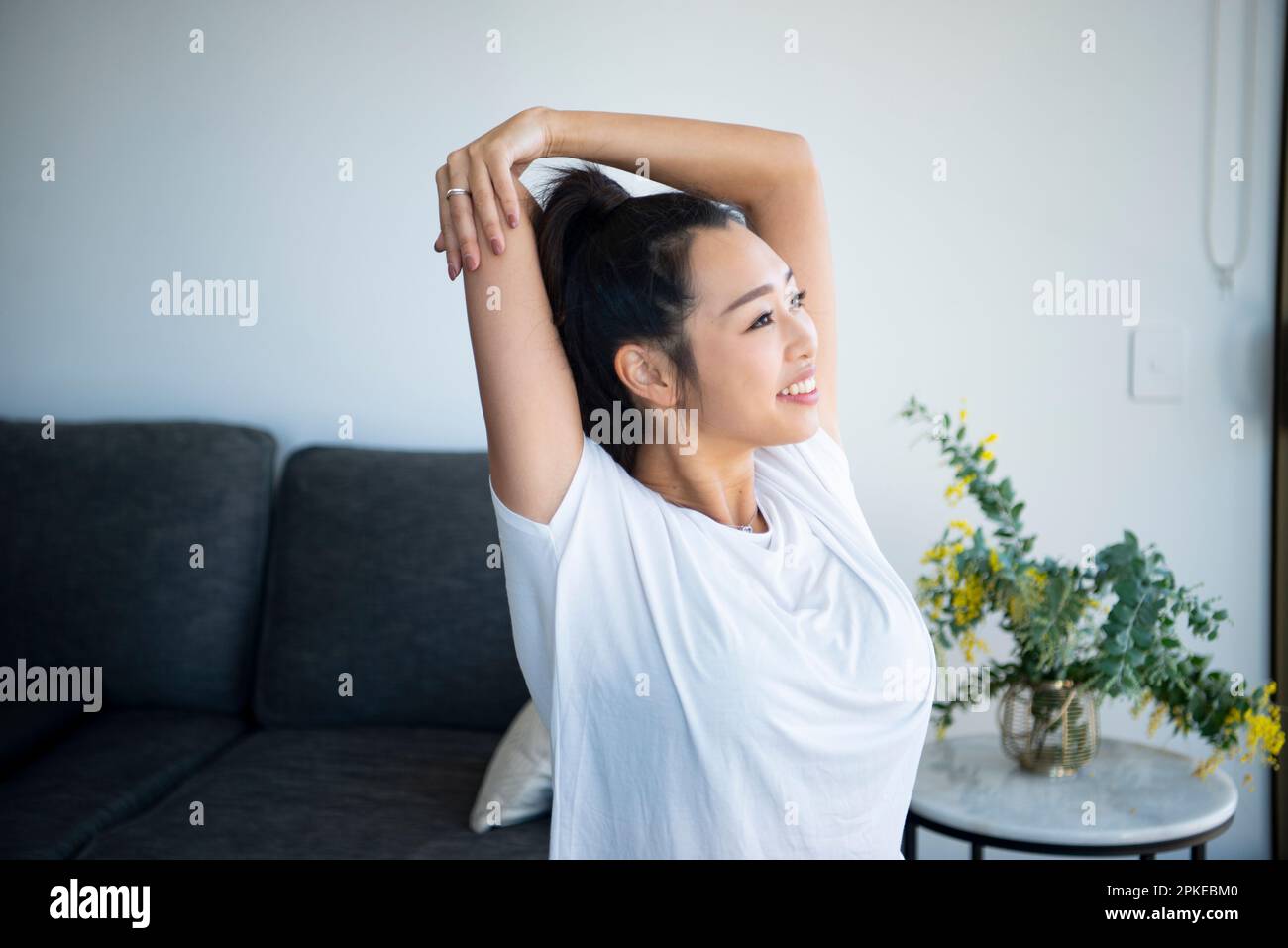 Woman laughing while stretching indoors Stock Photo - Alamy