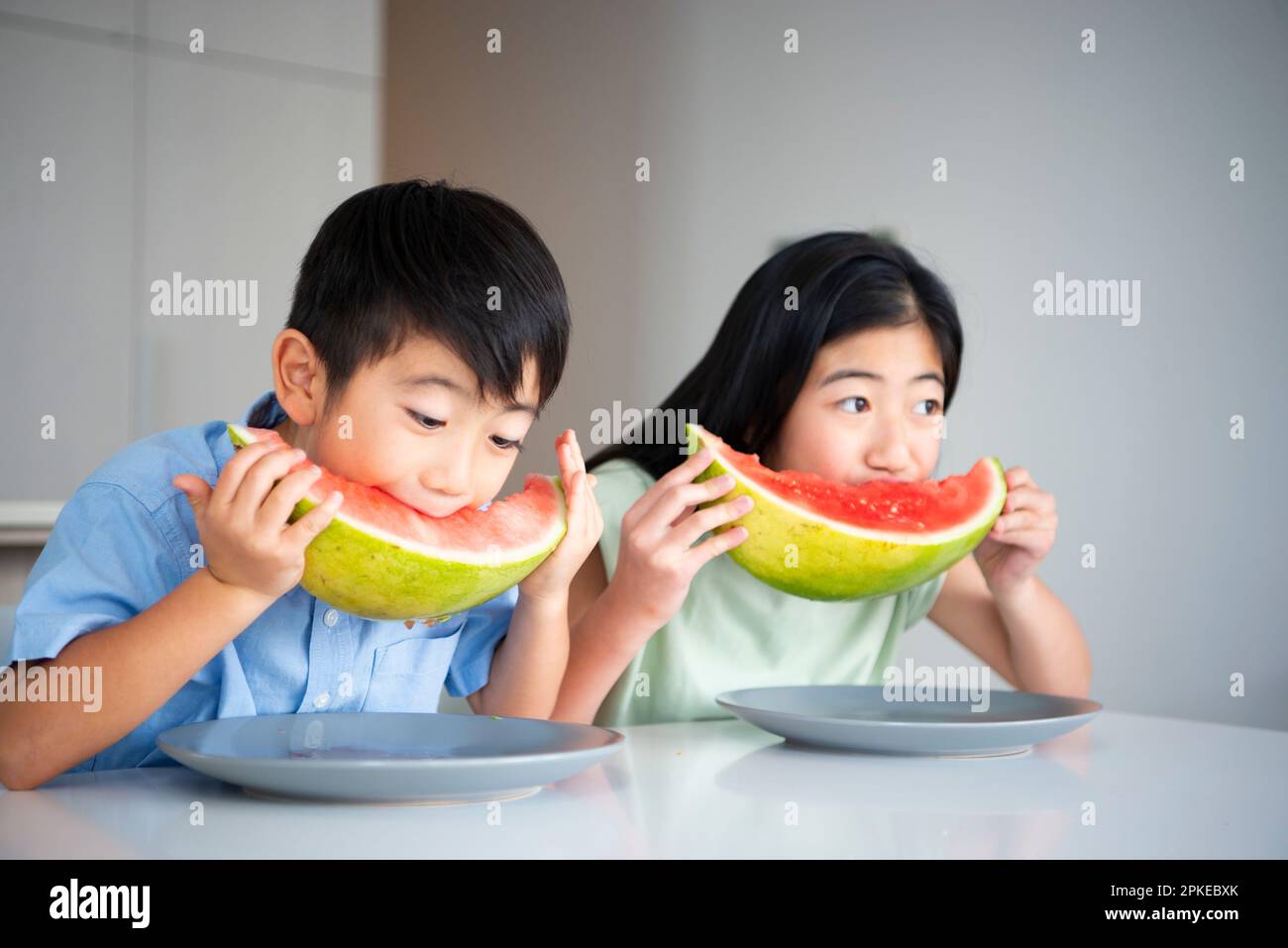 Brothers eating a big watermelon cut Stock Photo - Alamy