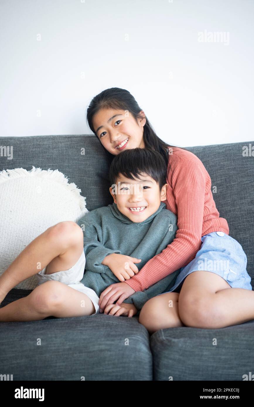 Smiling brothers laughing on the couch Stock Photo - Alamy