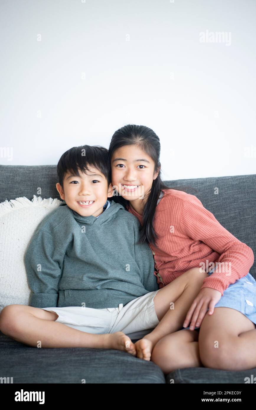 Smiling brothers laughing on the couch Stock Photo - Alamy