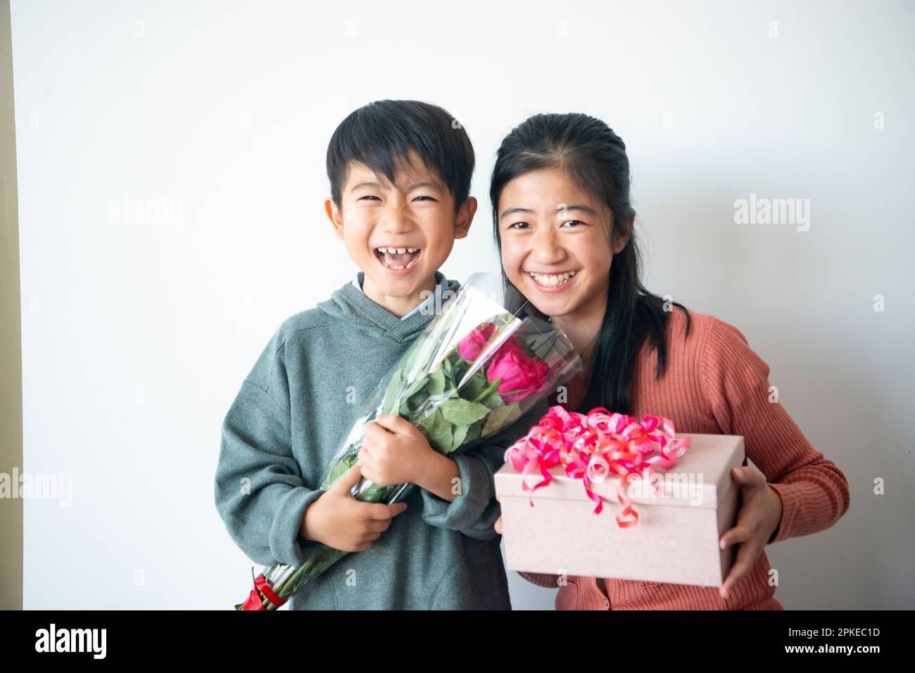 Boy and girl with bouquet of roses and presents Stock Photo - Alamy
