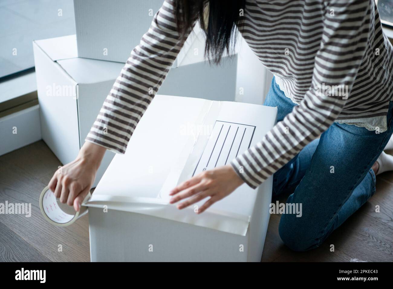 Woman putting duct tape on cardboard Stock Photo - Alamy
