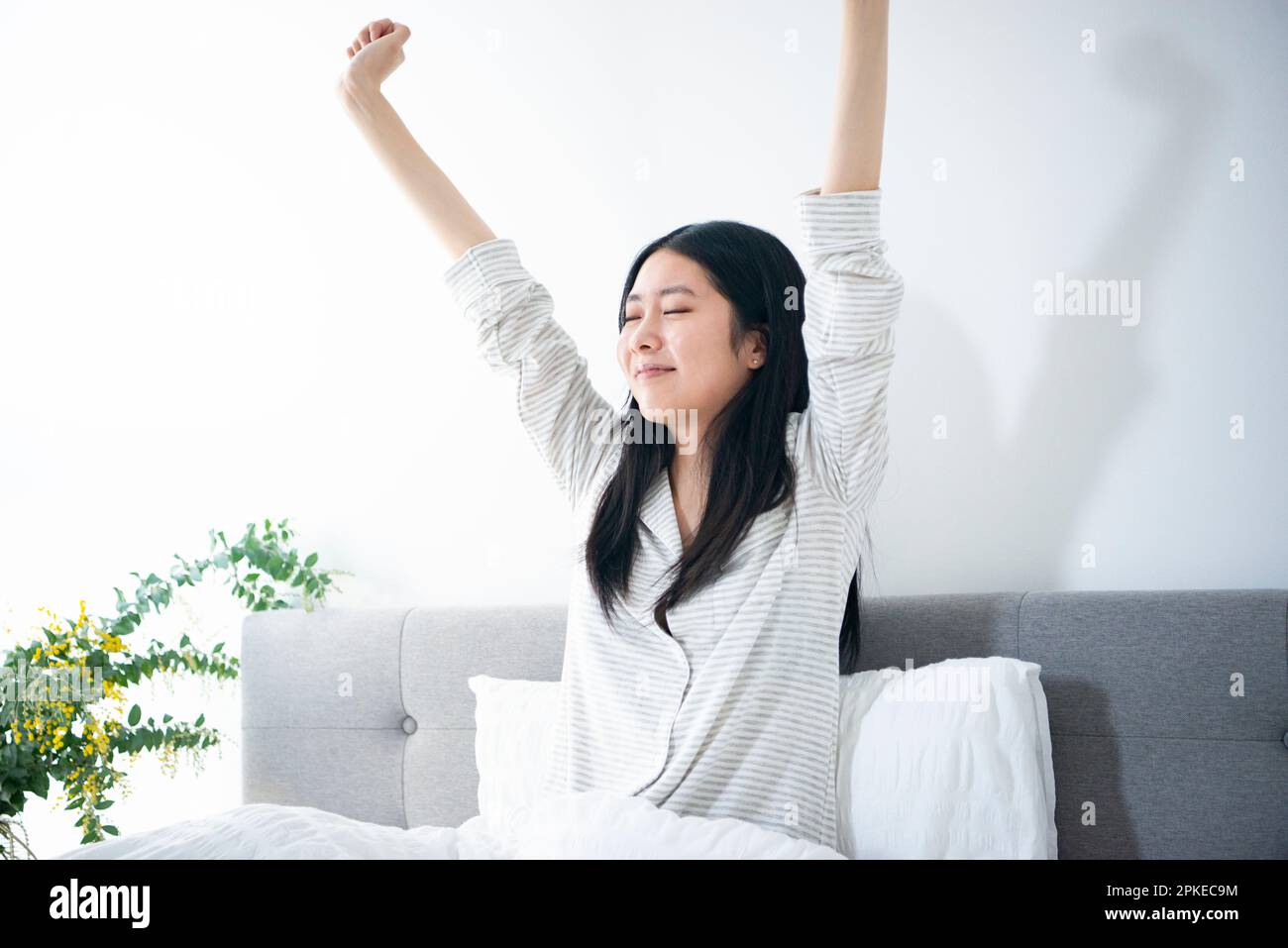 Woman stretching in bed Stock Photo - Alamy