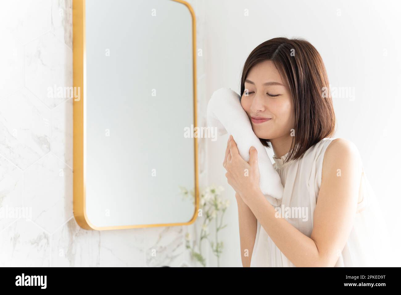 Woman wiping her face with a towel Stock Photo - Alamy