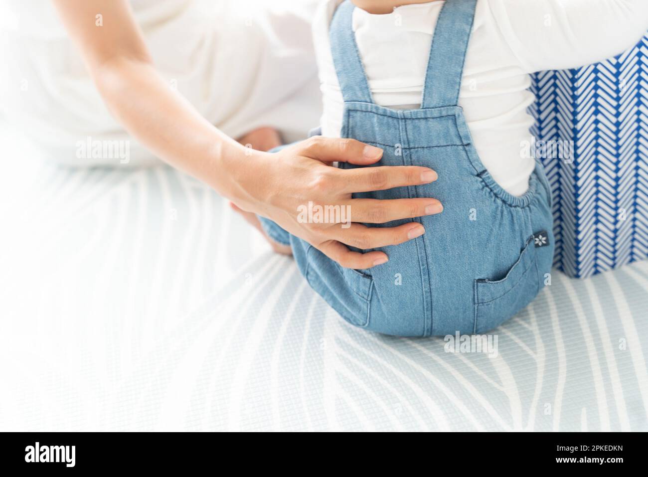 Mother's hand on baby's back Stock Photo - Alamy