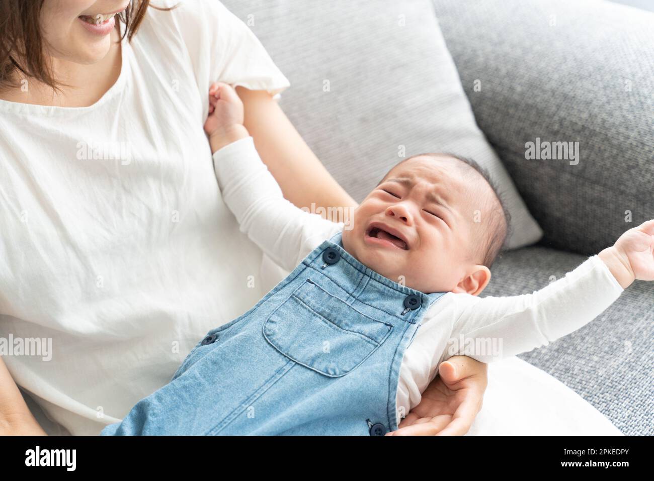 Baby boy crying on mother's lap Stock Photo - Alamy