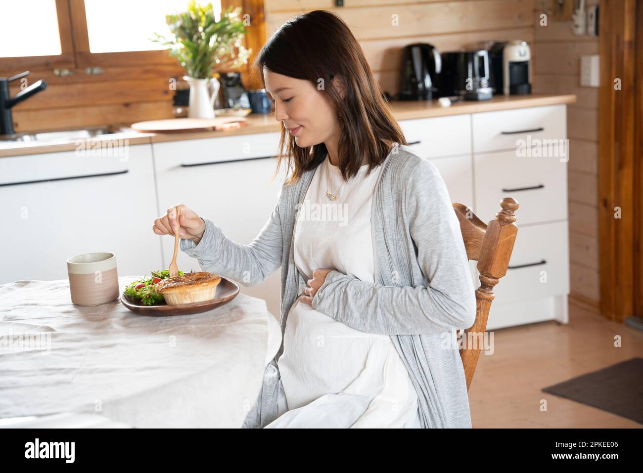 Pregnant woman eating at home Stock Photo - Alamy