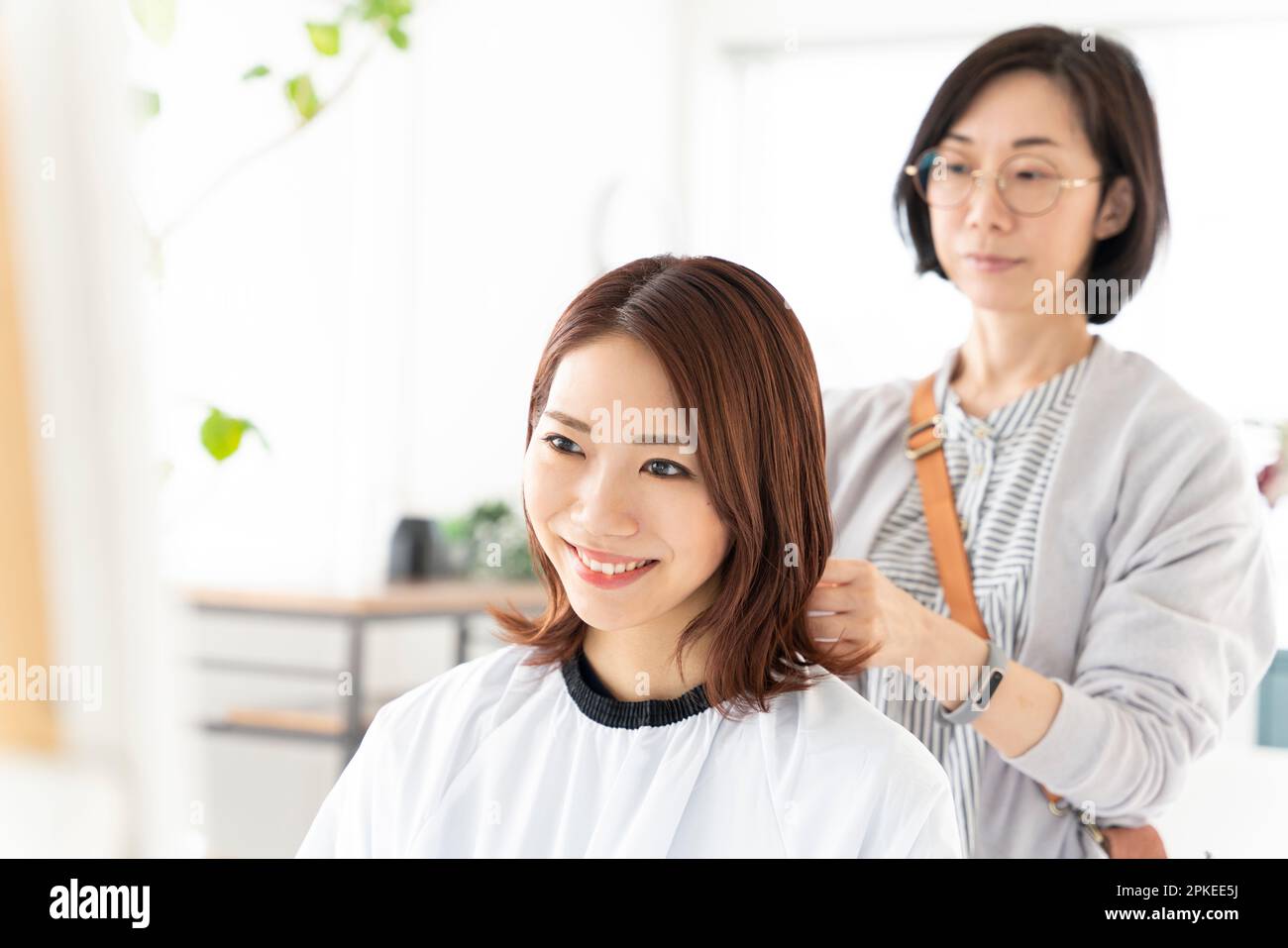 Woman giving a haircut at a hair salon Stock Photo - Alamy