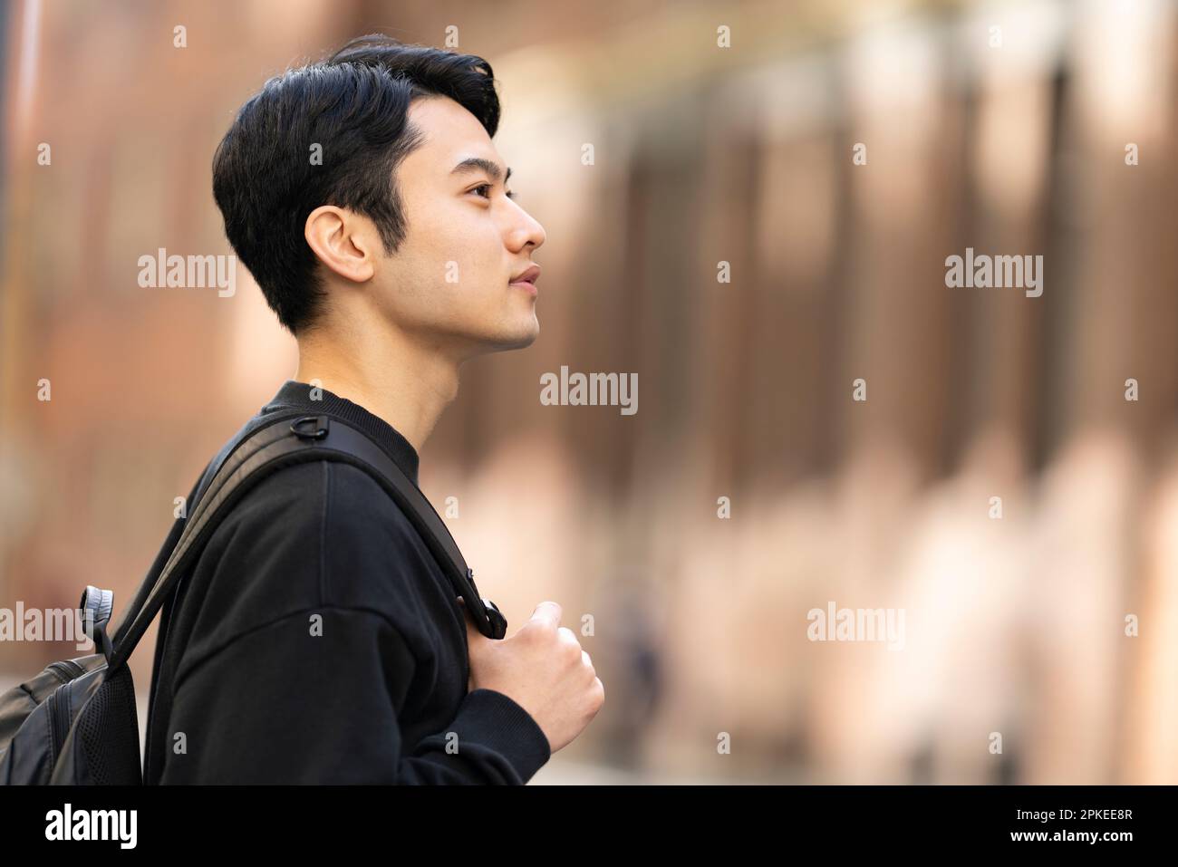 Man in profile in front of a brick building Stock Photo - Alamy