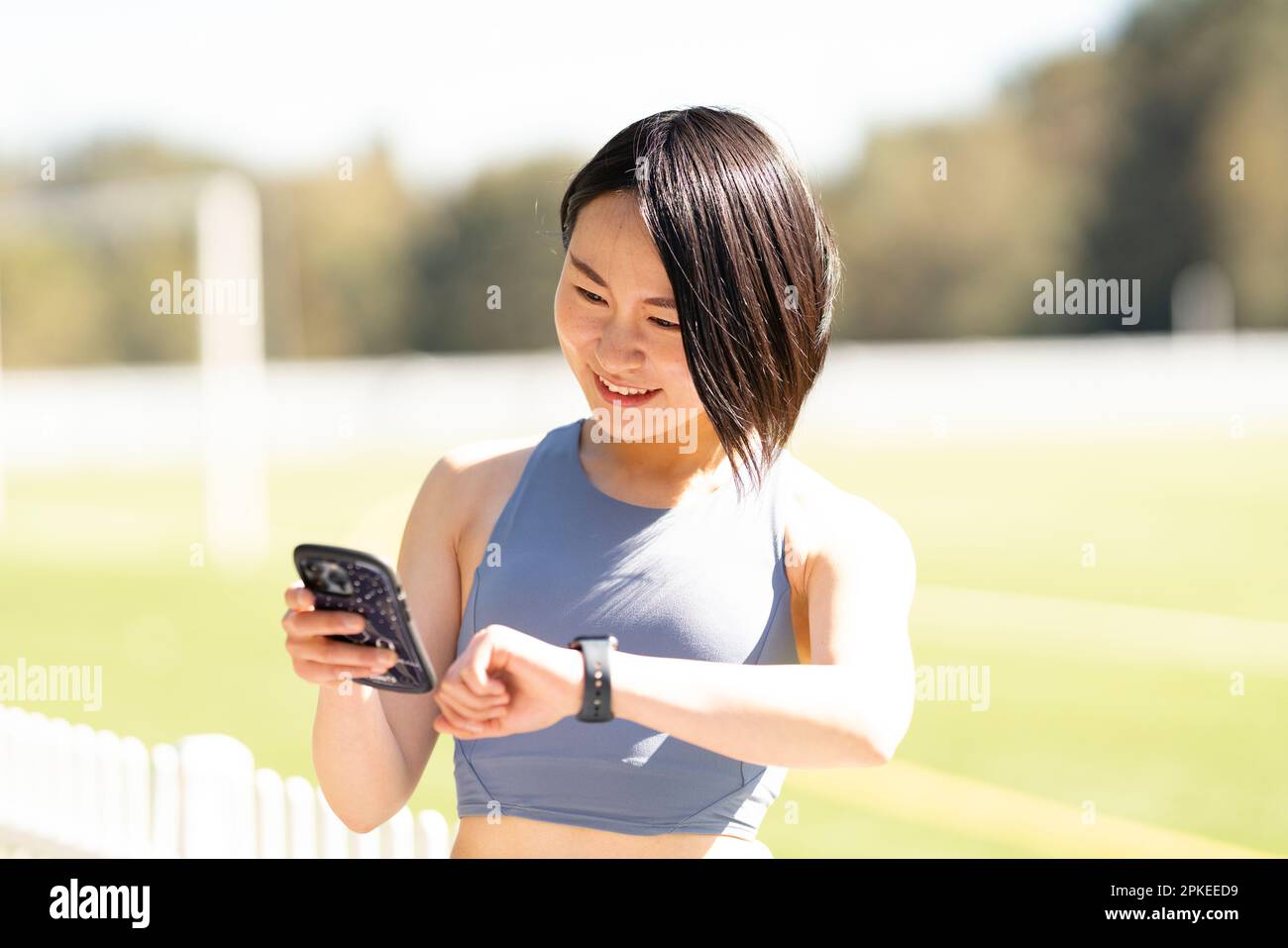 Woman checking her smartwatch and phone Stock Photo - Alamy