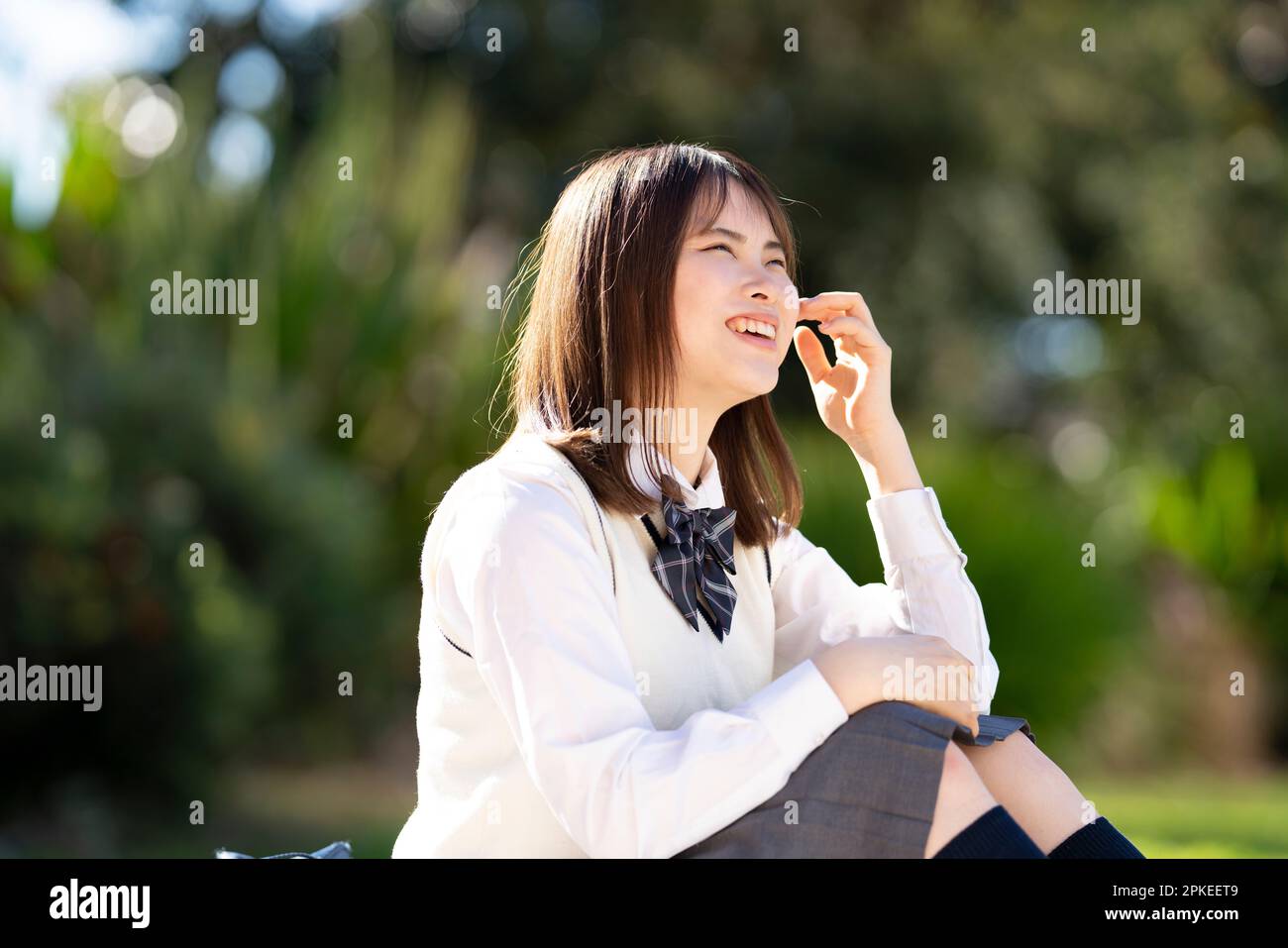 Female student in school uniform sitting and laughing Stock Photo - Alamy