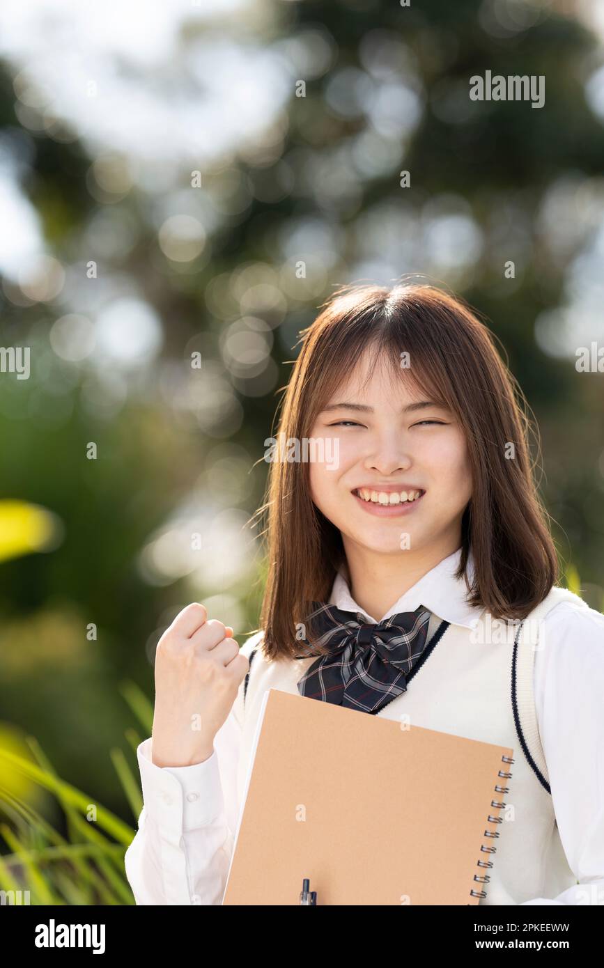 Female student in school uniform posing with notebook Stock Photo - Alamy