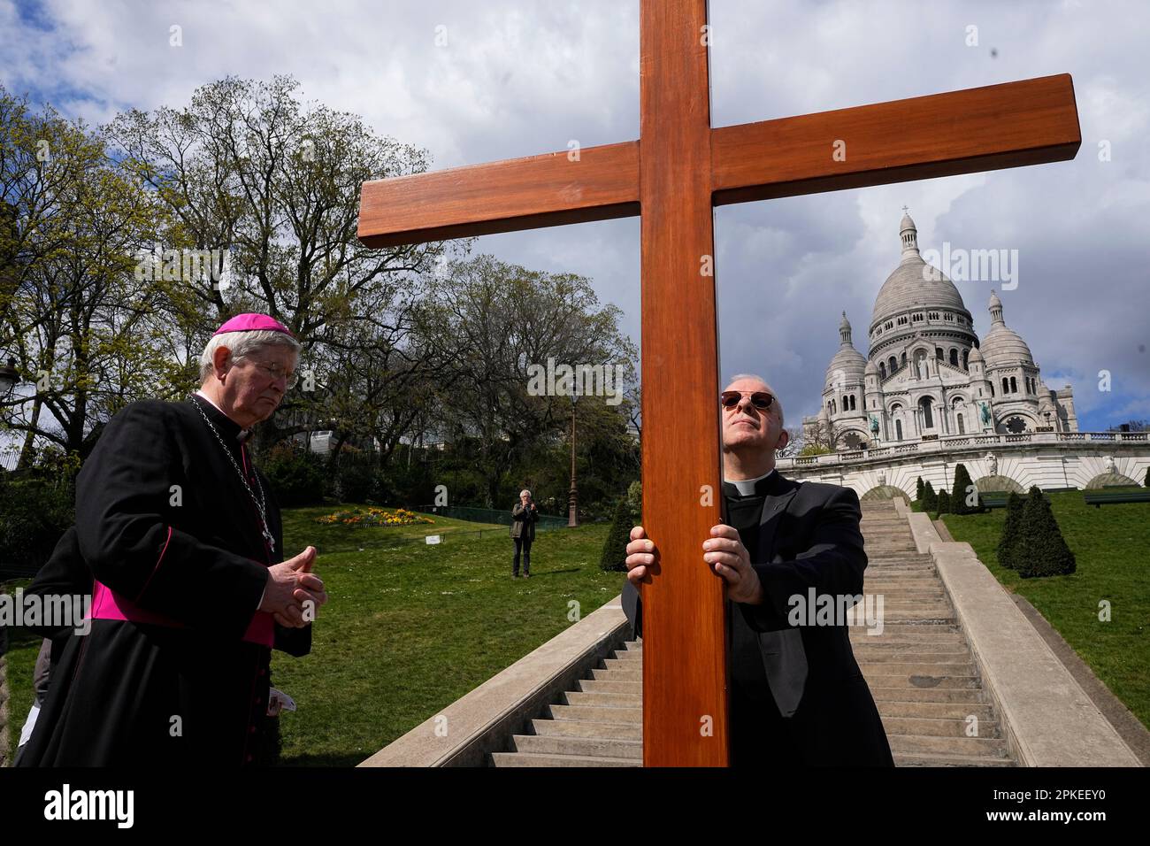 Paris Archbishop Laurent Ulrich, left, prays by a wooden cross in front ...
