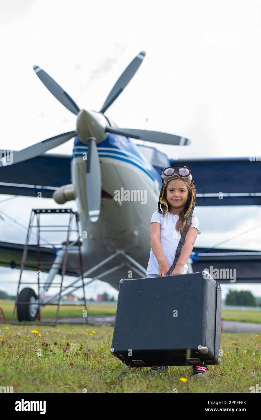 A cute little girl playing on the field by private jet dreaming of ...