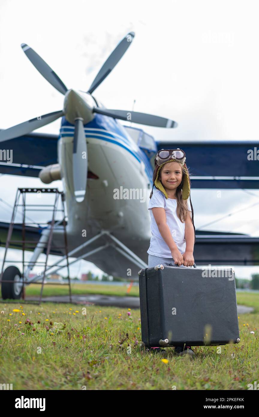 A cute little girl playing on the field by private jet dreaming of ...