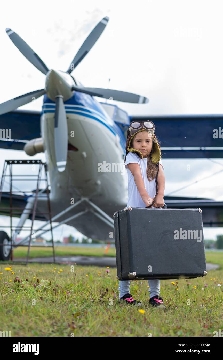A cute little girl playing on the field by private jet dreaming of ...
