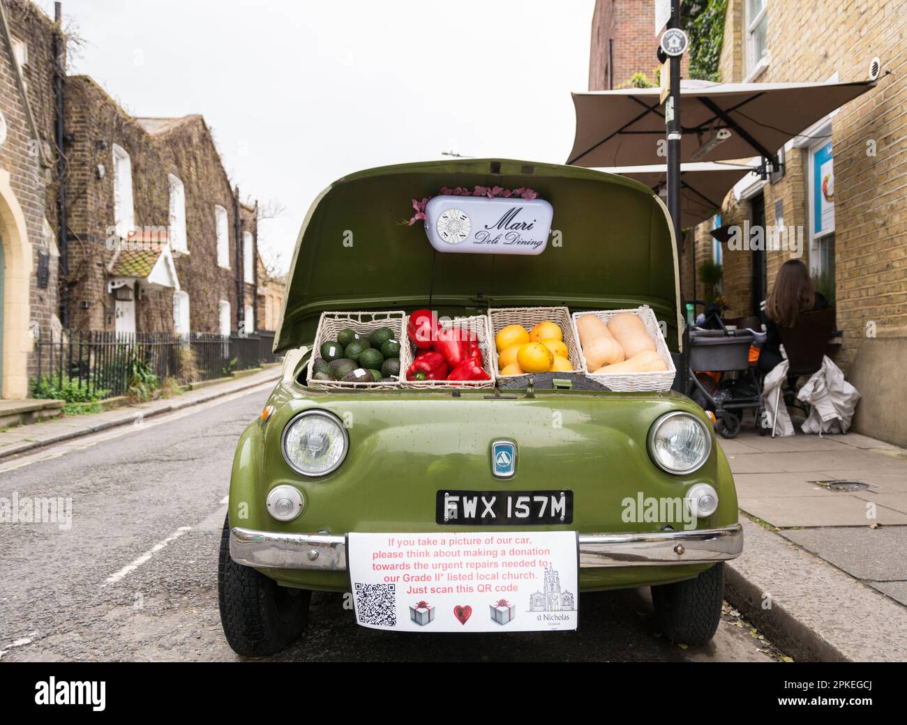 A small green Fiat packed with seasonal vegetables in front of Mari ...