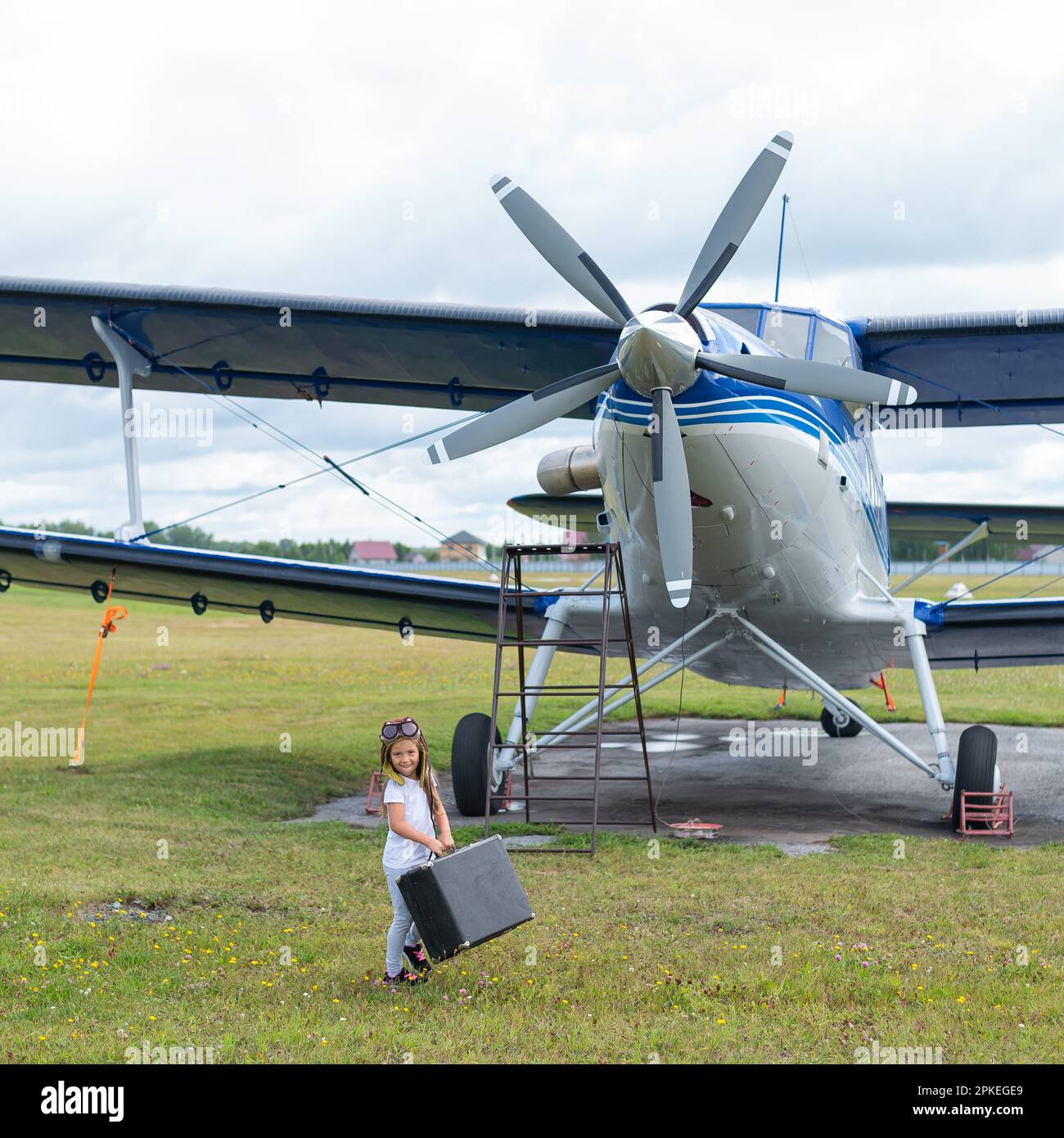 A cute little girl playing on the field by private jet dreaming of ...