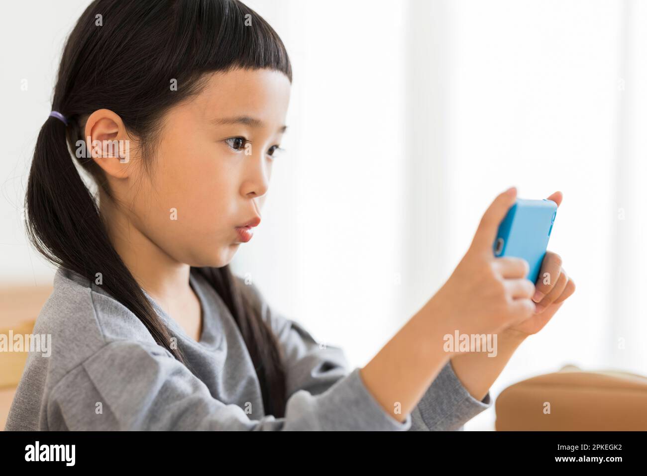 Girl studying while looking at her smartphone Stock Photo - Alamy