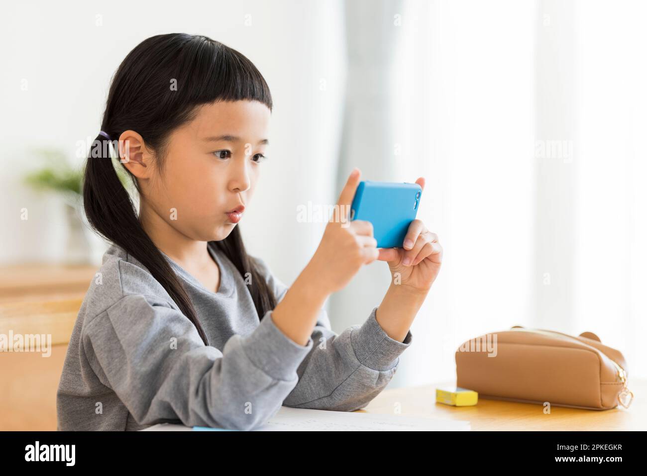 Girl studying while looking at her smartphone Stock Photo - Alamy