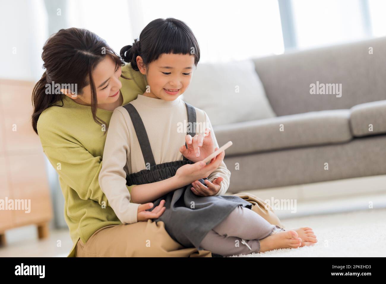 Parent and child looking at smartphone Stock Photo - Alamy