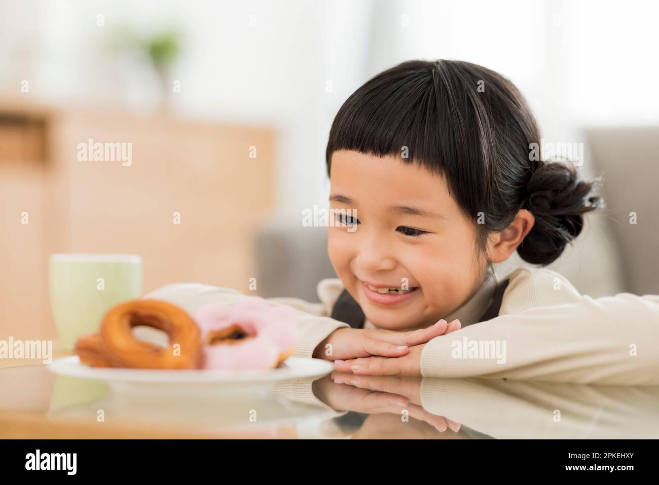 Smiling girl staring at donuts Stock Photo - Alamy