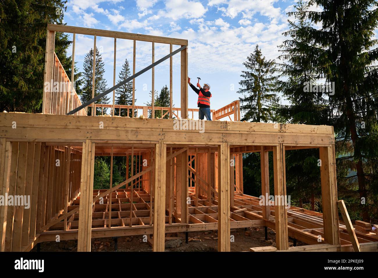 Wooden two-story, frame-built home is being erected by the carpenter ...