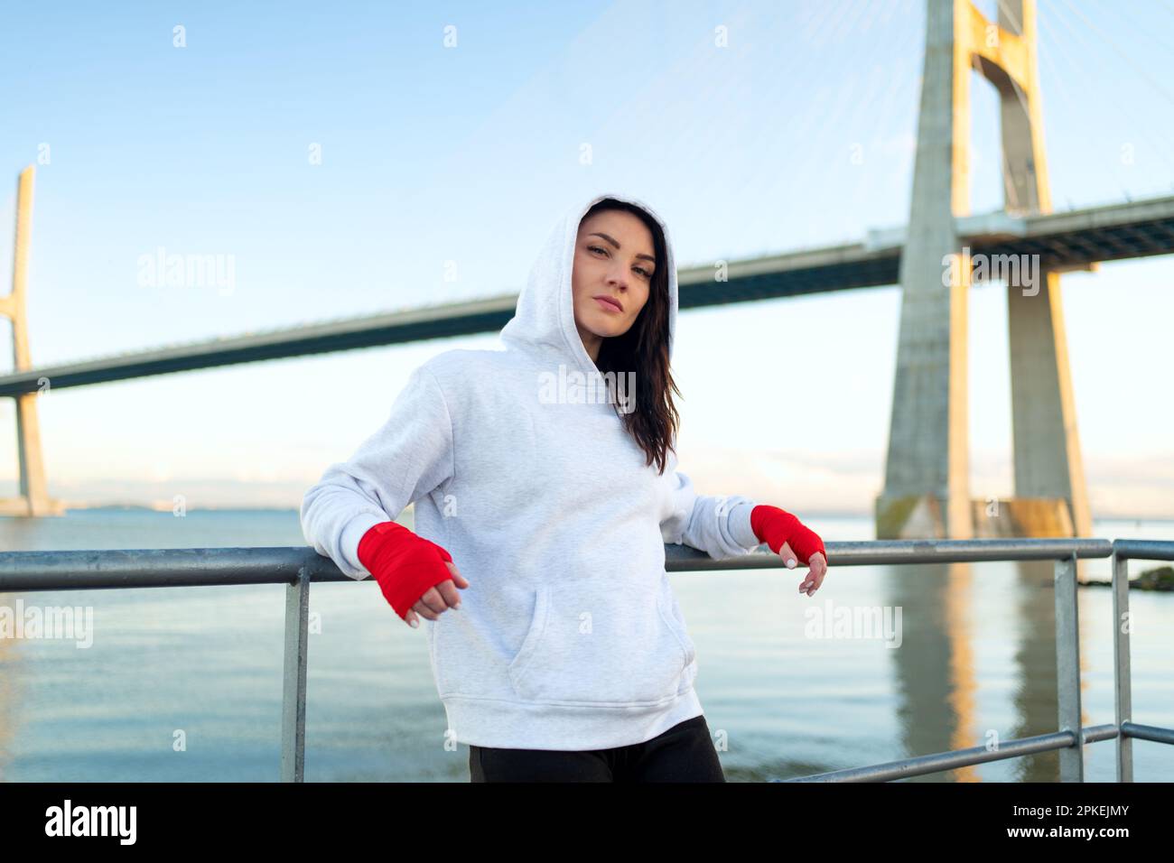 Female boxer staring, looking in camera lean on fence powerful and ...