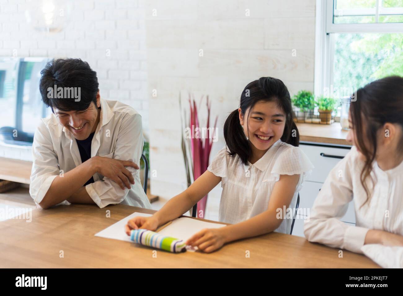 Parents watching over an elementary school girl studying Stock Photo ...