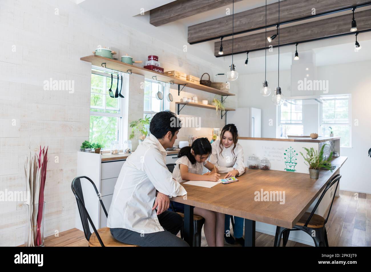 Parents watching over an elementary school girl studying Stock Photo ...