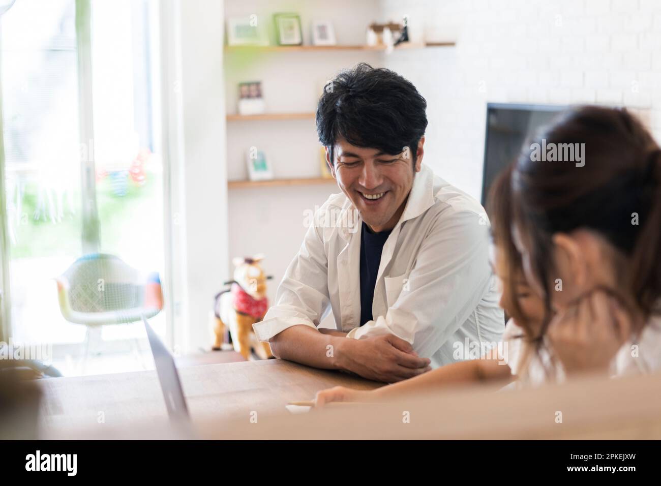 Elementary school girl studying with her parents watching over her ...