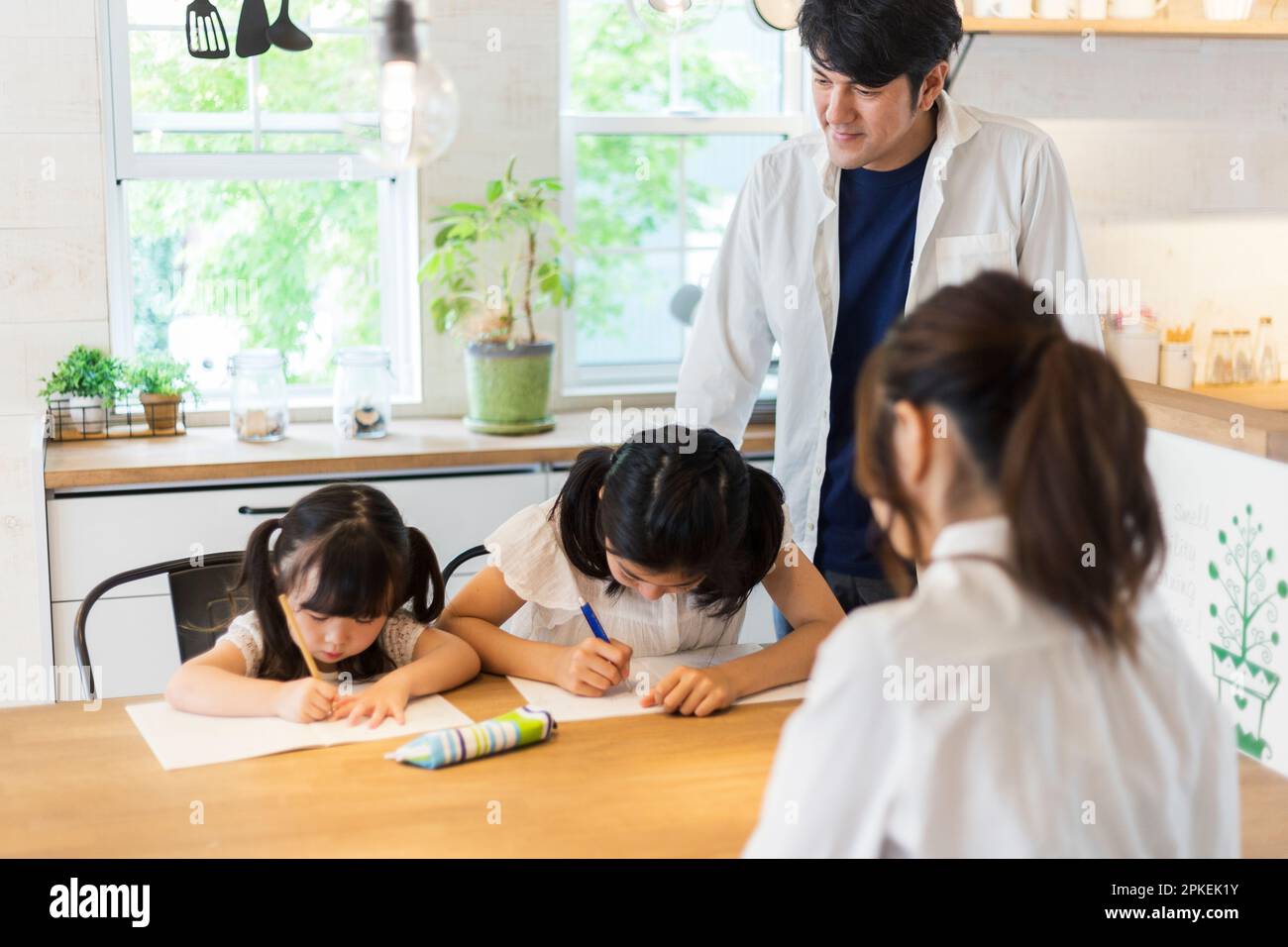 Sisters studying and their parents watching over them Stock Photo - Alamy